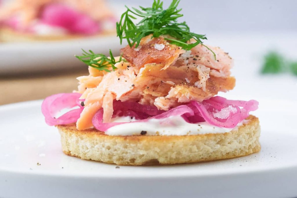 Ristet brød med varmrøget laks og syltede rødløg - Nem forret